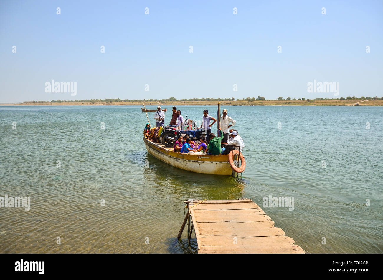 A crowded rowboat leaving the dock on Narmada river at Nareshwar ...