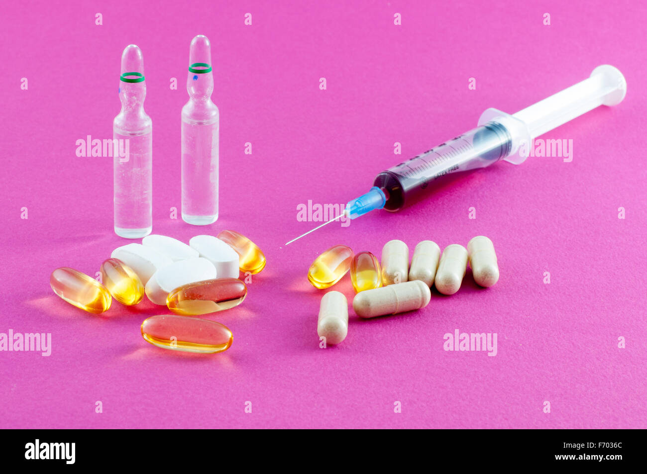 Phials, pills and syringe on pink background Stock Photo - Alamy
