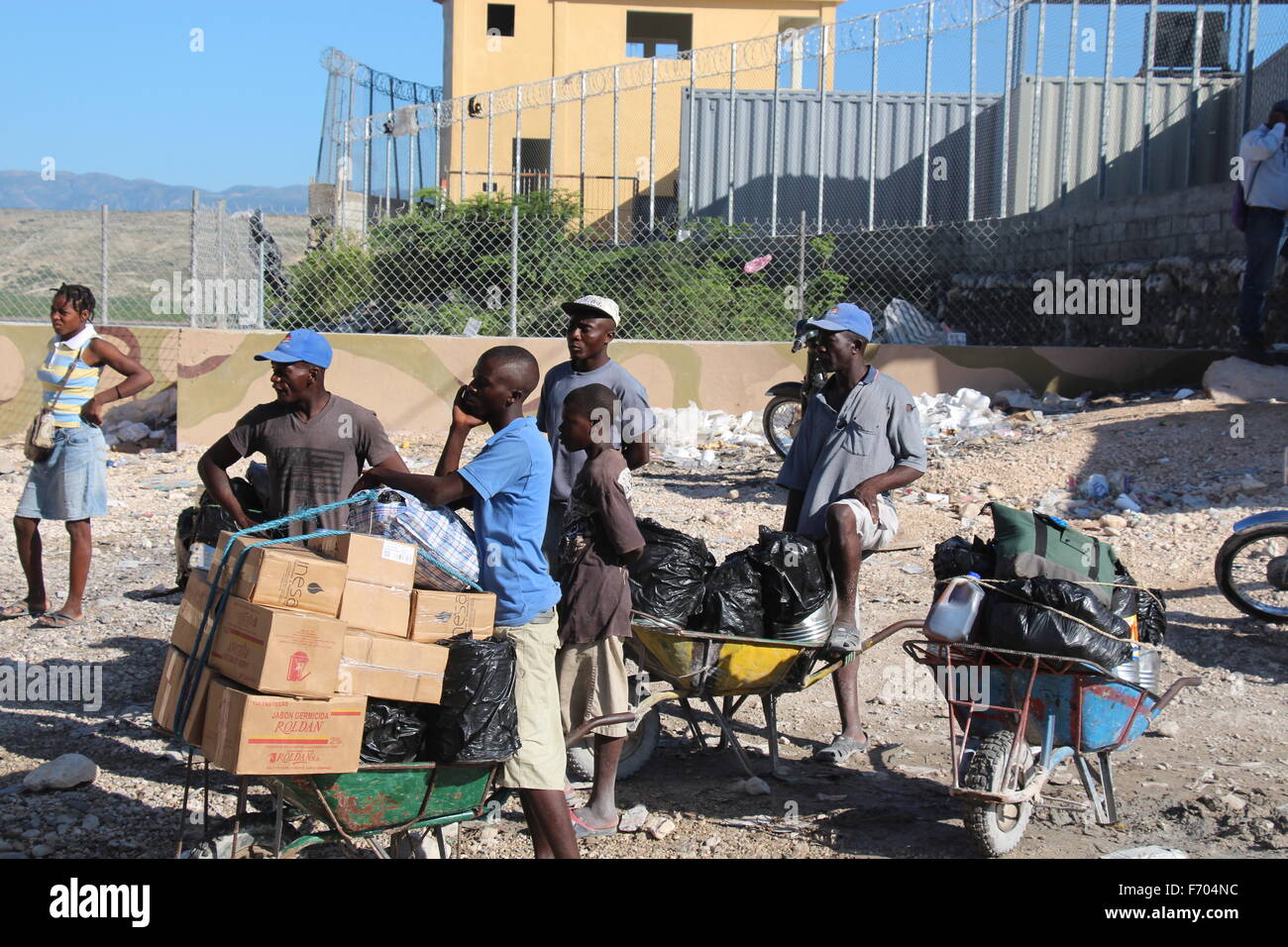 Haitian workers wait on the Dominican side of the border between Haiti ...