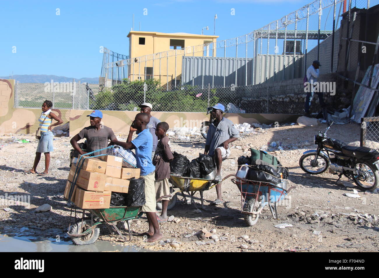 Haitian workers wait on the Dominican side of the border between Haiti ...