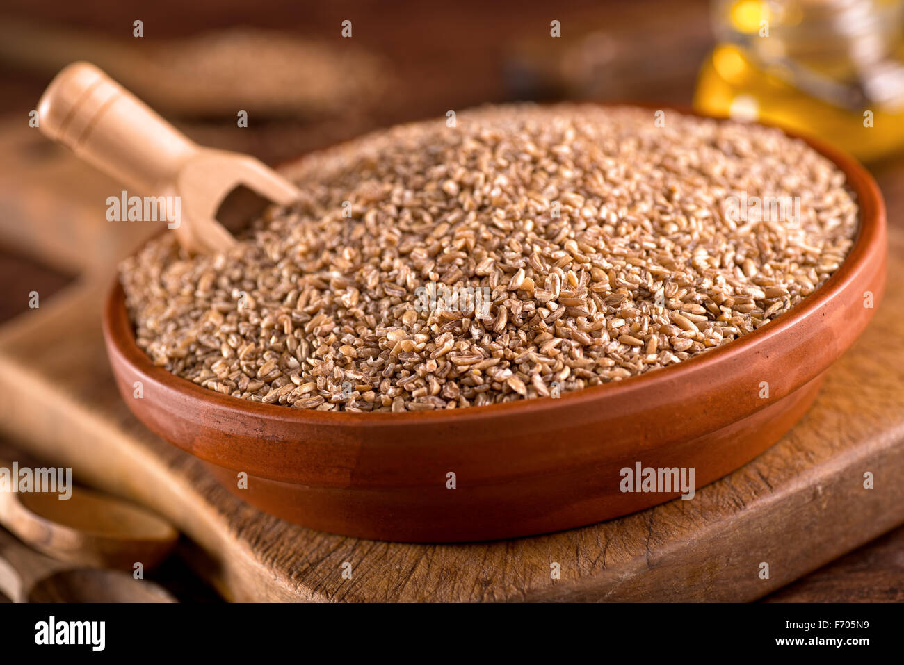A bowl of raw bulgar wheat against a rustic background Stock Photo - Alamy
