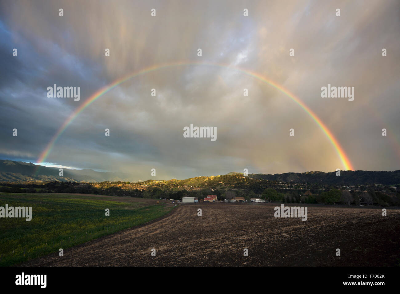 Oak View, California, USA, March 1, 2015, full rainbow over rain storm ...