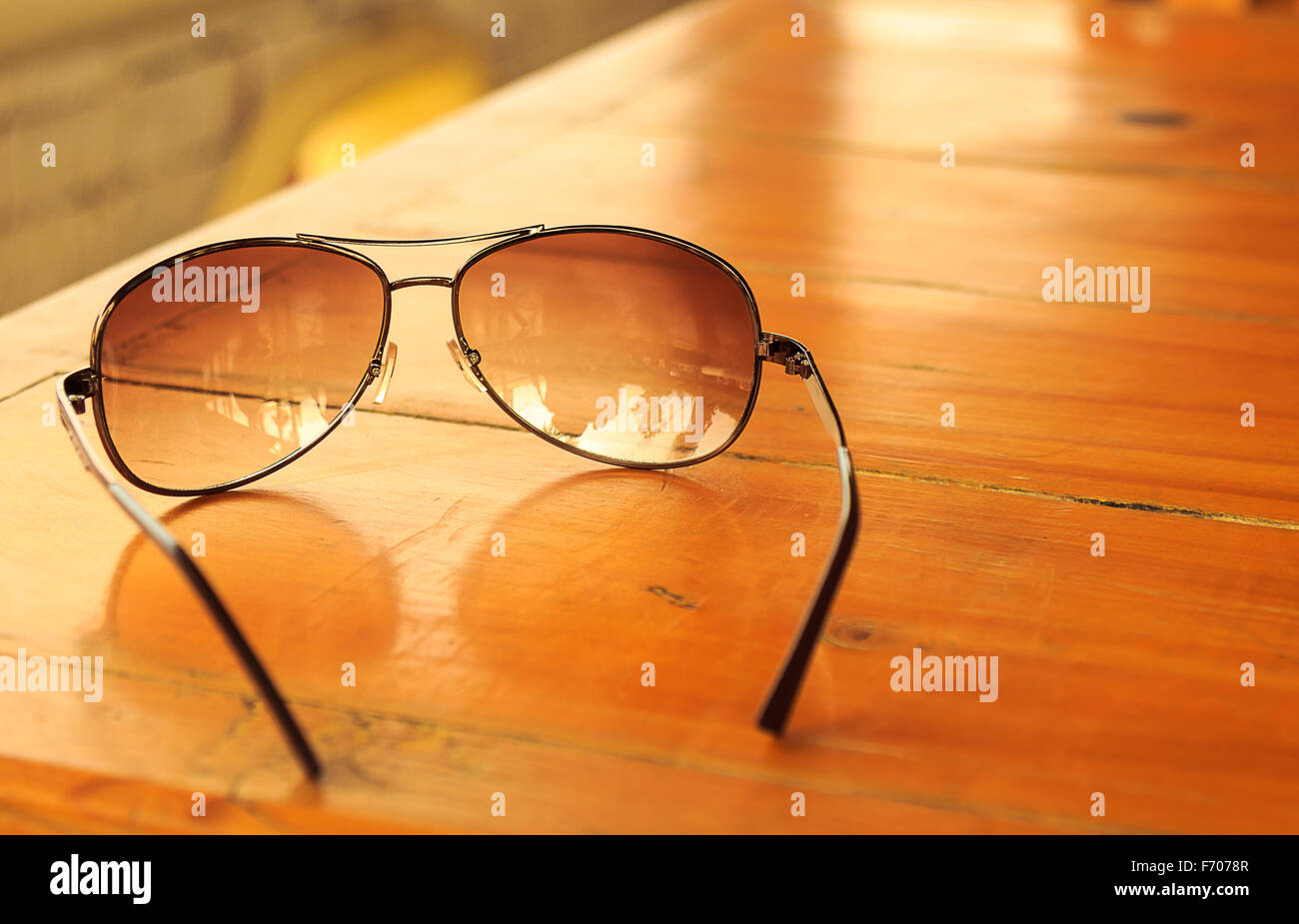 Light brown mirrored sunglasses on the wooden table Stock Photo - Alamy