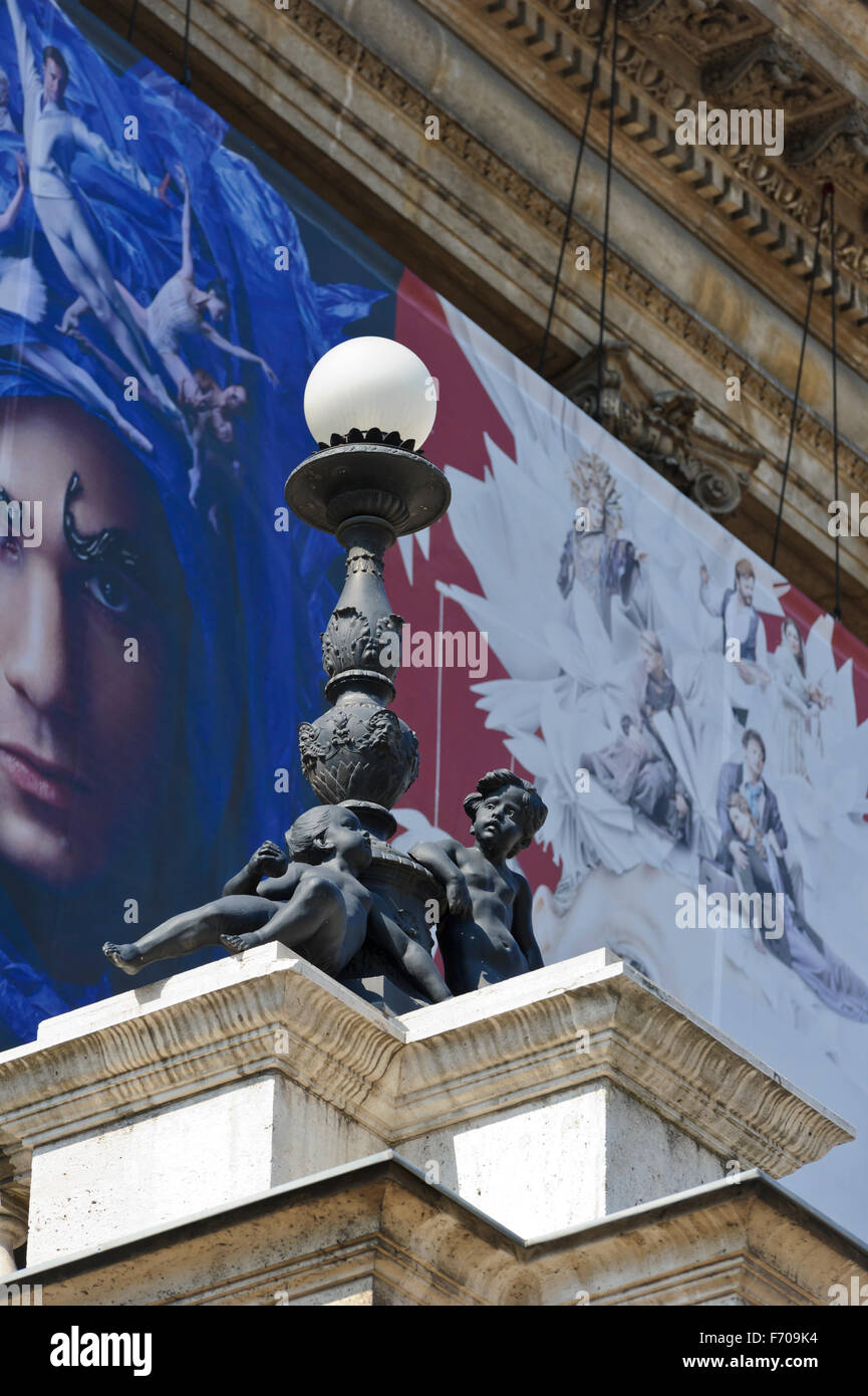 A decorative lamp post with cherubs sculptures on the facade of the ...