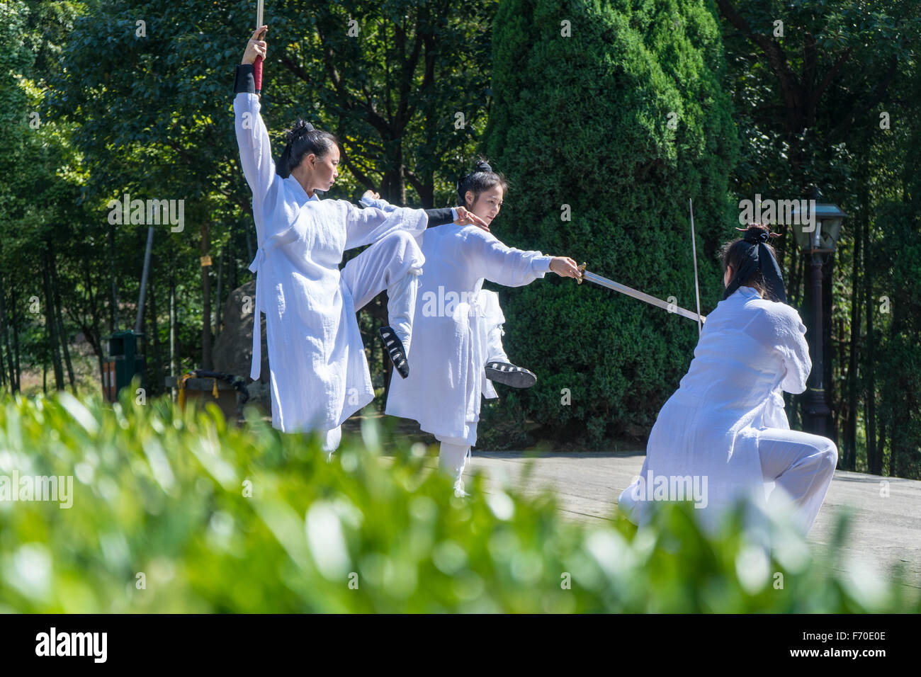 Three women practicing sword-play outside a Doist temple in Jinhua ...