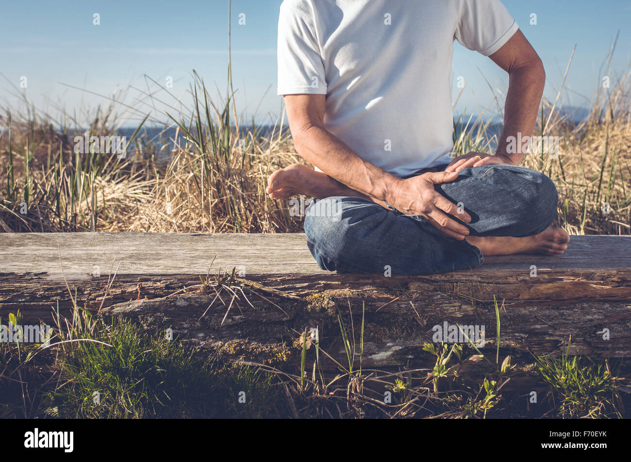 Mature fit older man in his sixties, practicing mindfulness, meditation ...