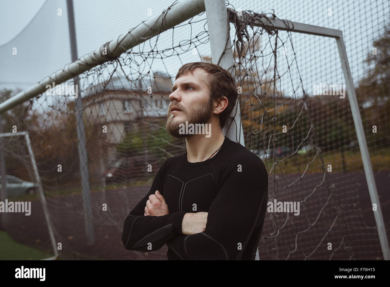 Male athlete resting on soccer field urban view Stock Photo - Alamy