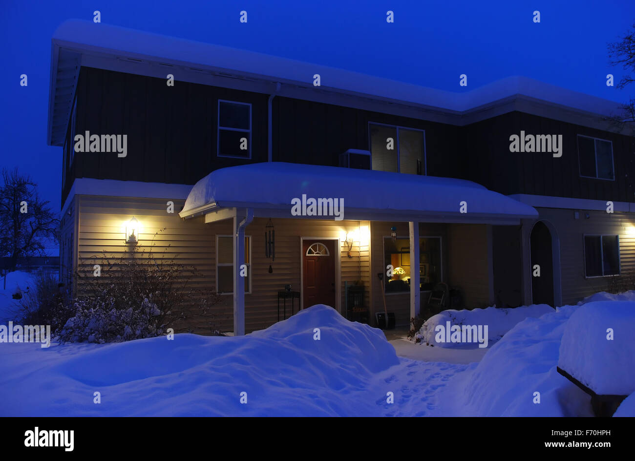 Front porch of home surrounded by snow in winter at twilight Stock ...