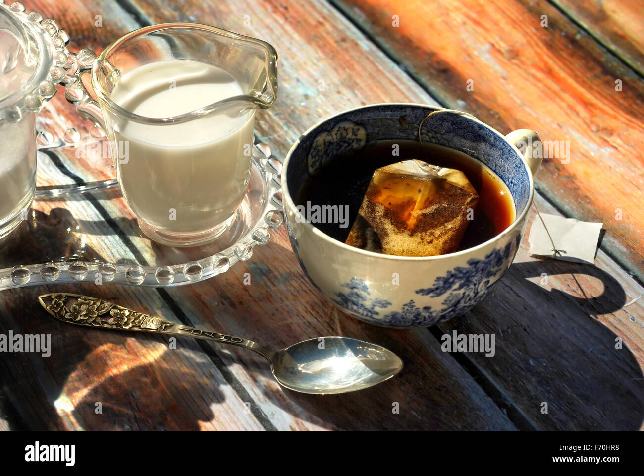 Cup of tea in antique cup with milk and sugar on rustic background ...