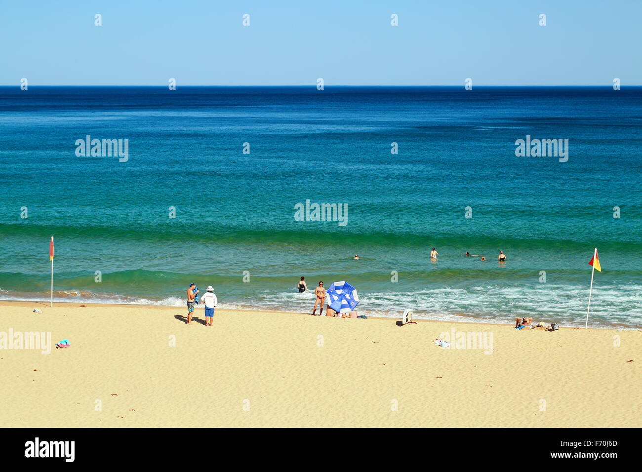 Beachgoers enjoying the refreshing ocean on a beautiful calm summer ...