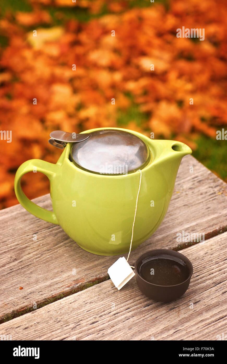 Tea pot with cup on autumn table Stock Photo - Alamy