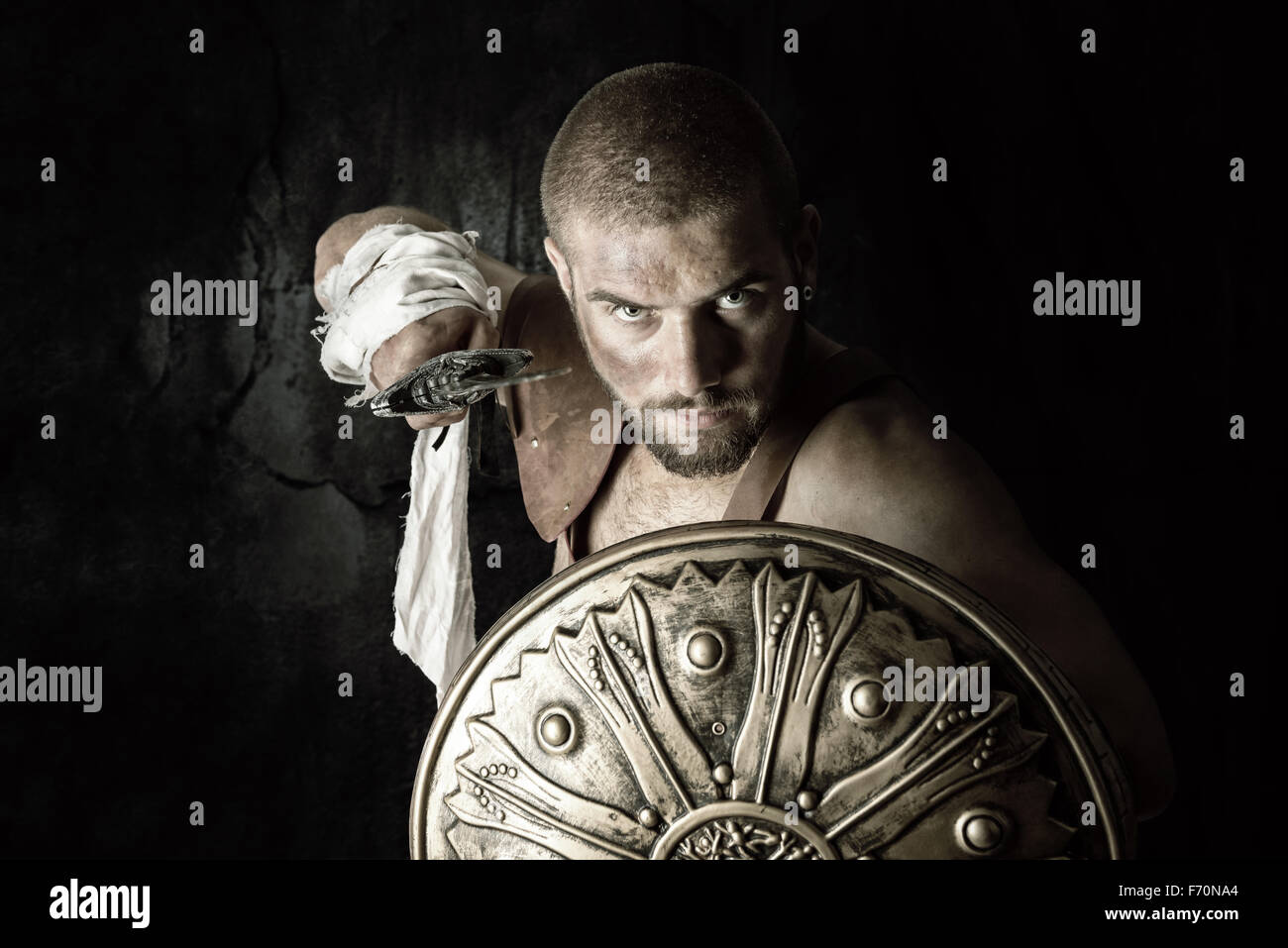 Gladiator posing with shield and sword in a dark background Stock Photo ...