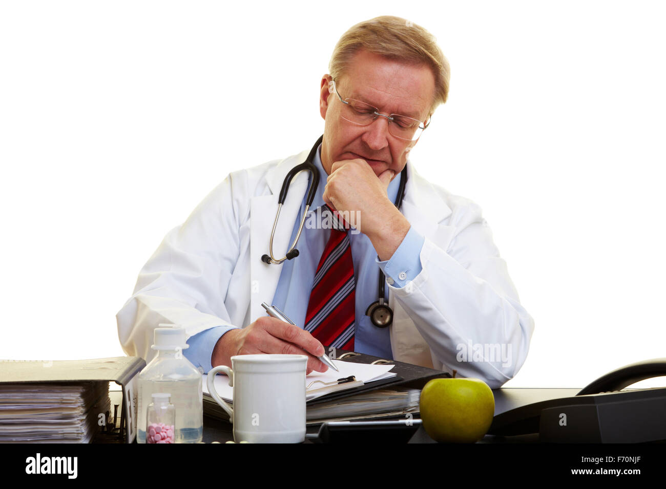 Physician sitting at a desk and taking notes Stock Photo - Alamy