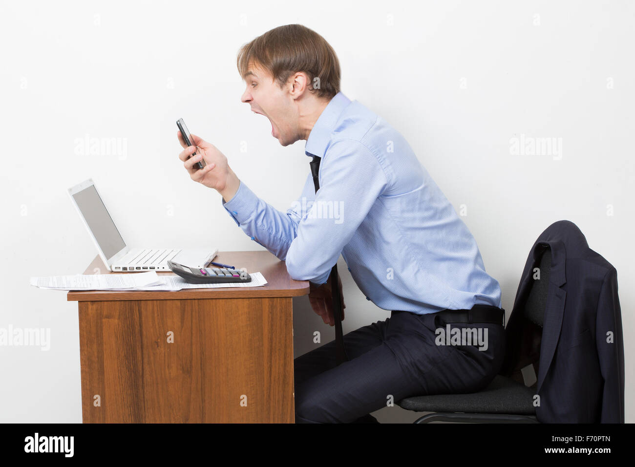 angry office worker yelling into the phone Stock Photo - Alamy