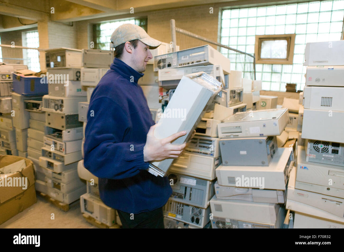 Man piling up worn out computers at recycling plant Stock Photo - Alamy