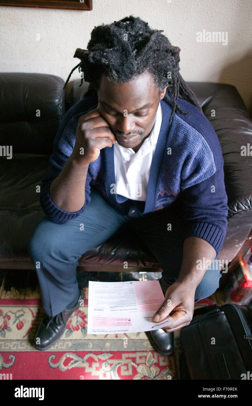 Man reading a utility bill in his home Stock Photo - Alamy