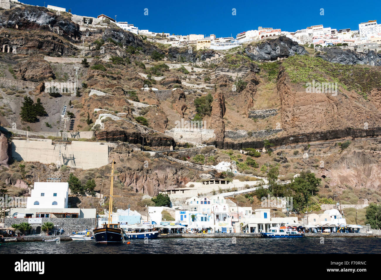 Santorini. View from the sea. Seafront at base of cliffs, with zig-zag ...