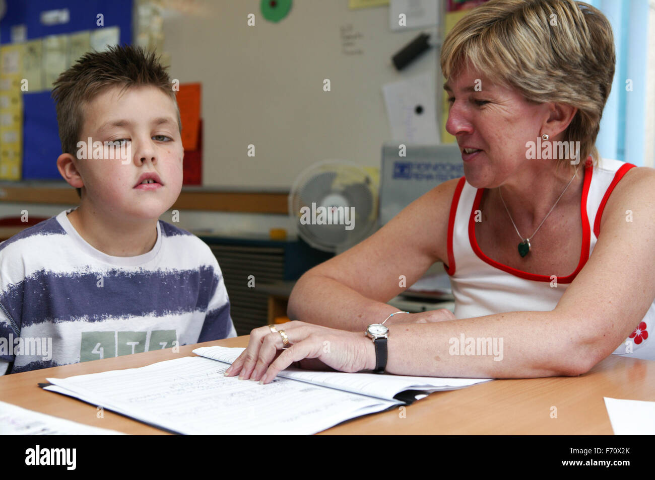 Special needs teacher in classroom with young boy Stock Photo - Alamy