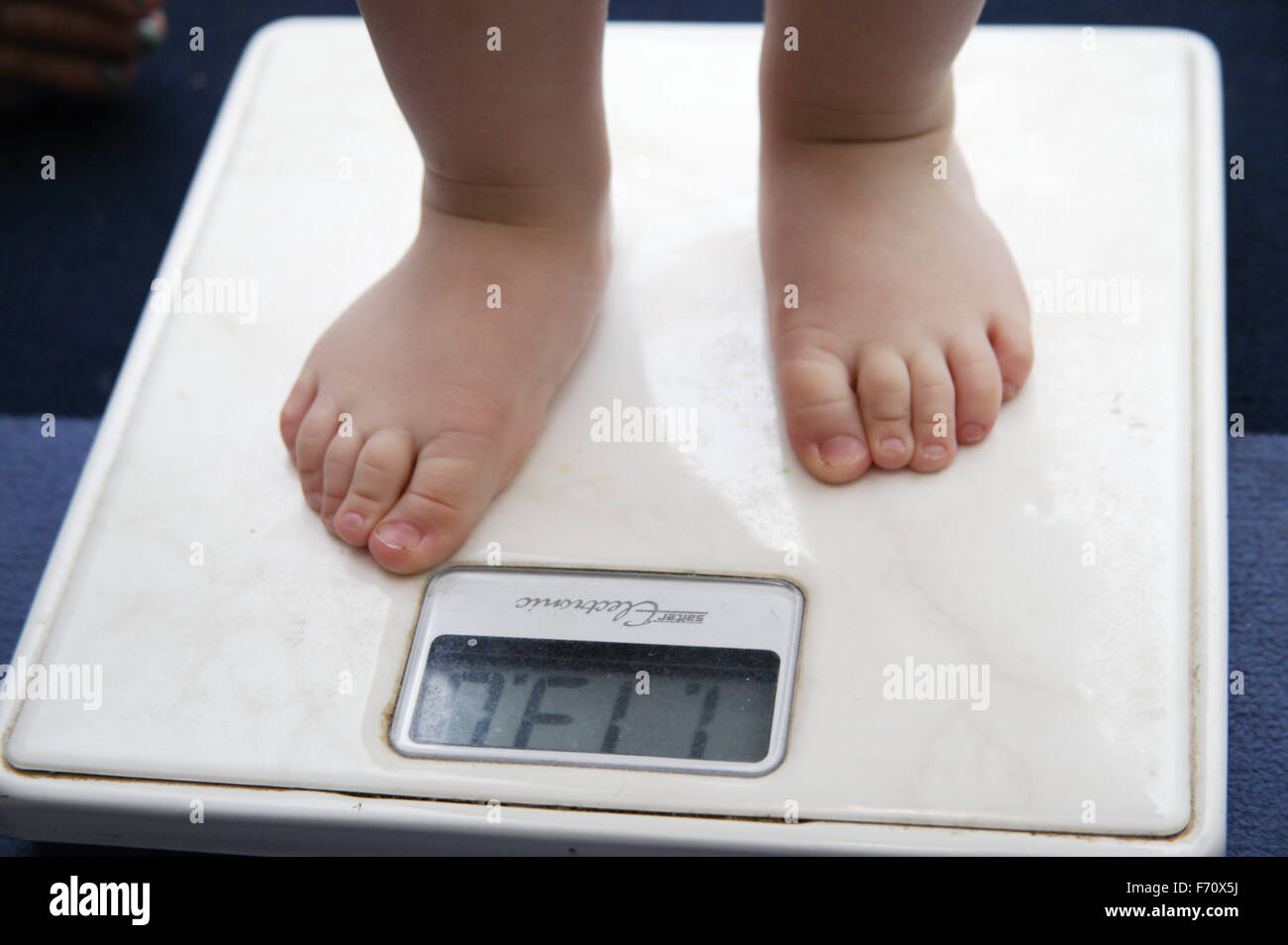 Child on weighing scales hi-res stock photography and images - Alamy
