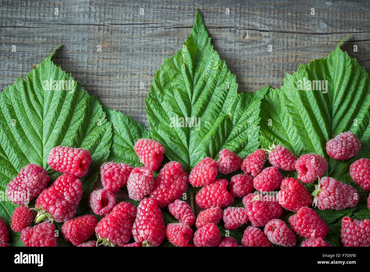 Raspberry with leaves on old wooden plank Stock Photo - Alamy