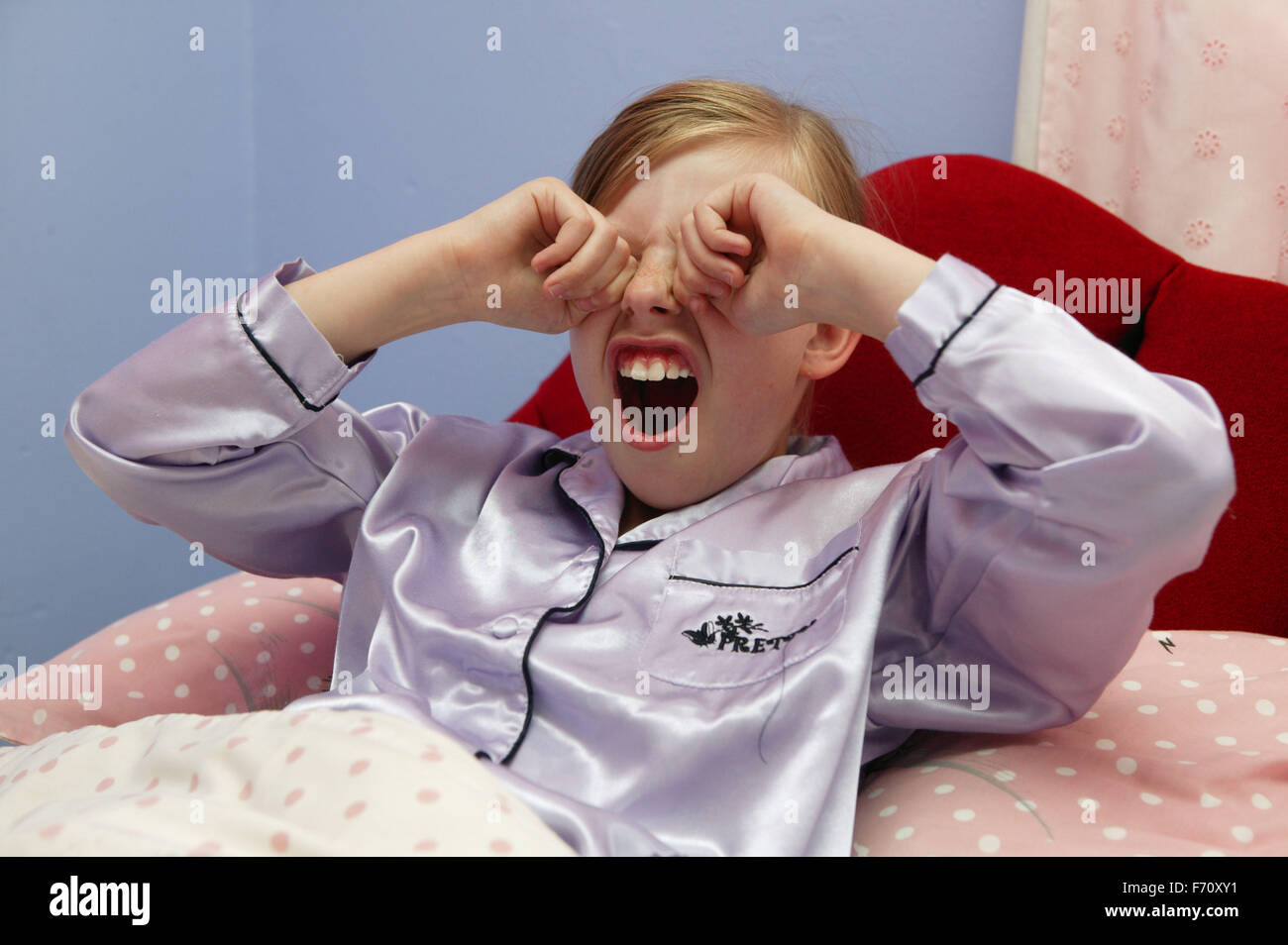 Girl rubbing eyes waking up Stock Photo - Alamy