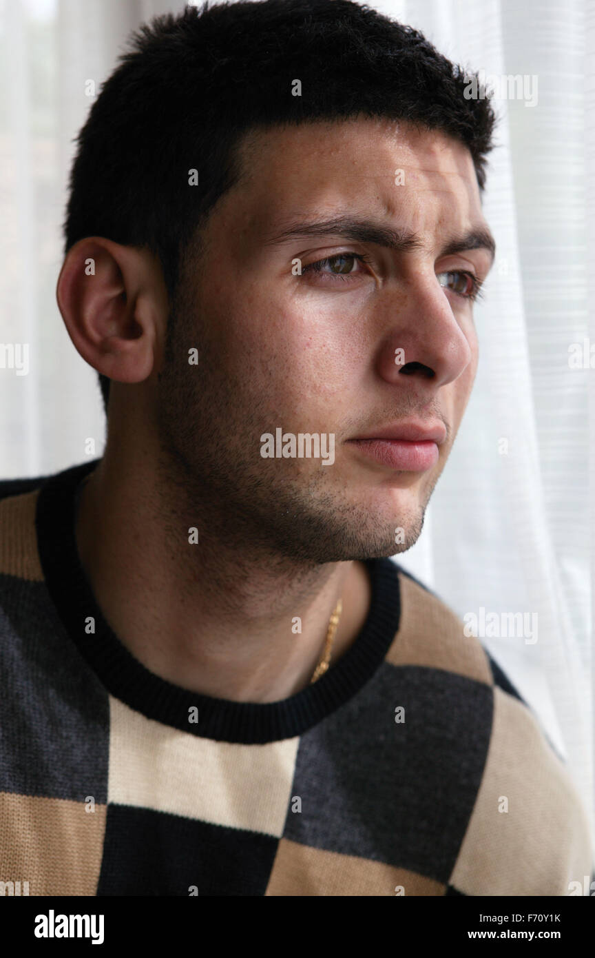 Portrait of a young man by a window; model released for use in HIV and ...
