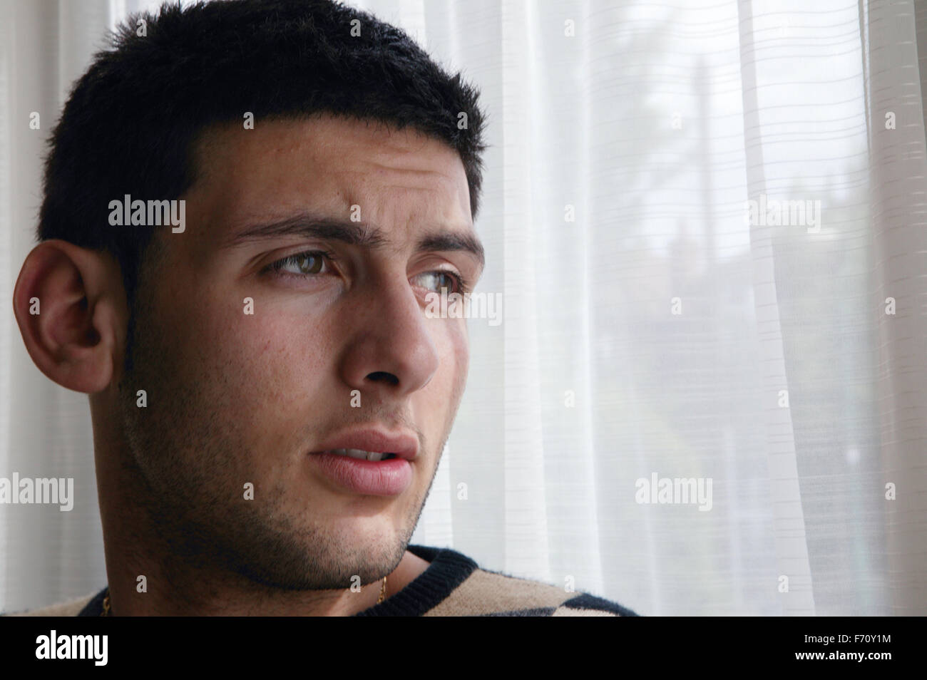 Portrait of a young man by a window; model released for use in HIV and ...