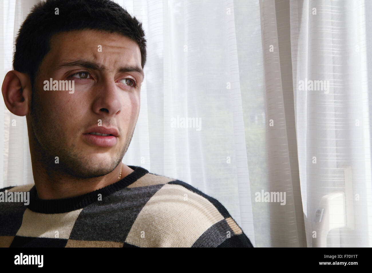 Portrait of a young man by a window; model released for use in HIV and ...