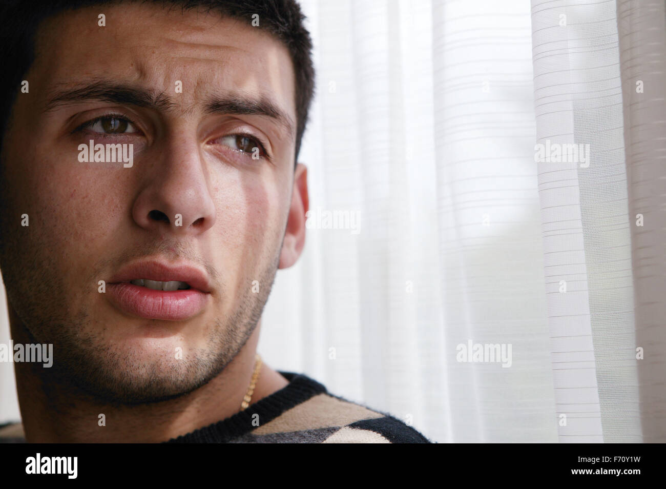 Portrait of a young man by a window; model released for use in HIV and ...