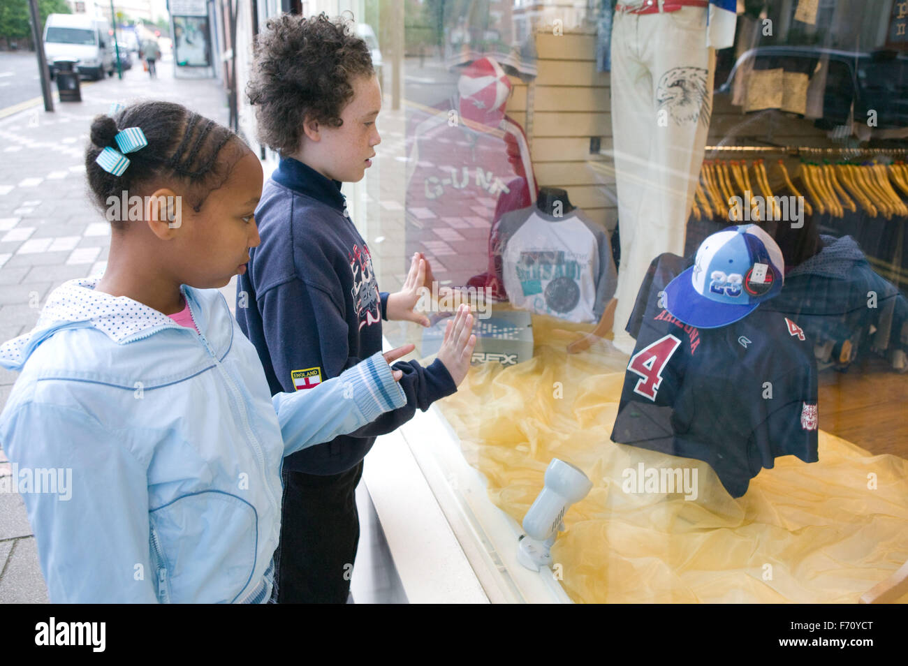 Two young friends out window shopping together Stock Photo - Alamy