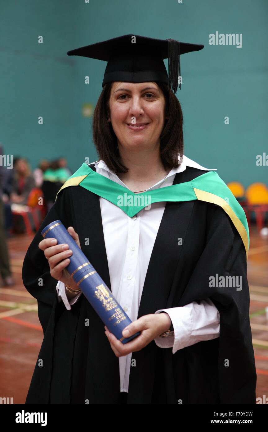 Portrait of woman in graduation gown holding certificate Stock Photo ...