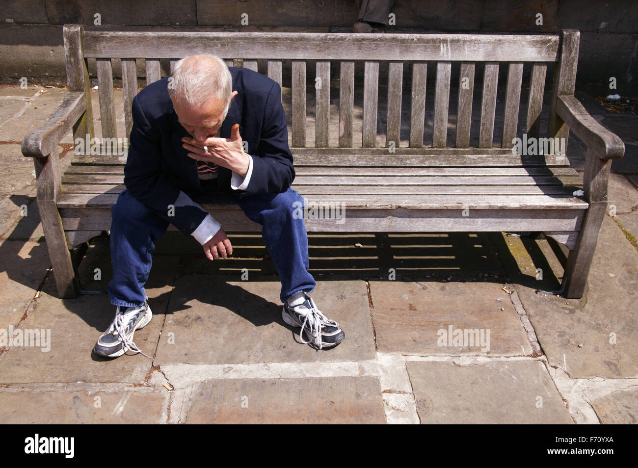 Man sitting on a bench smoking; Community Care Project user Stock Photo ...