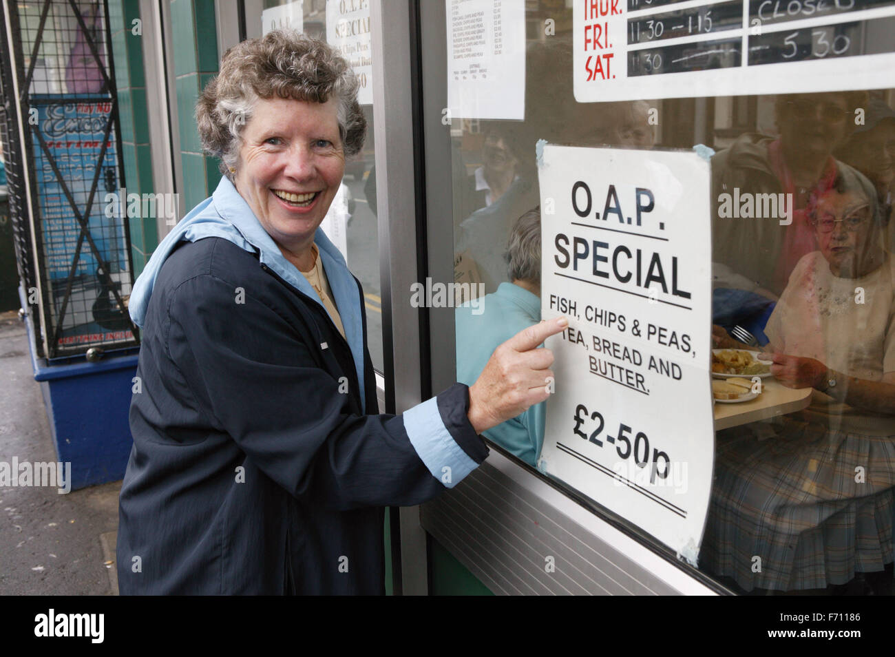 Elderly woman pointing to poster outside a cafe Stock Photo - Alamy