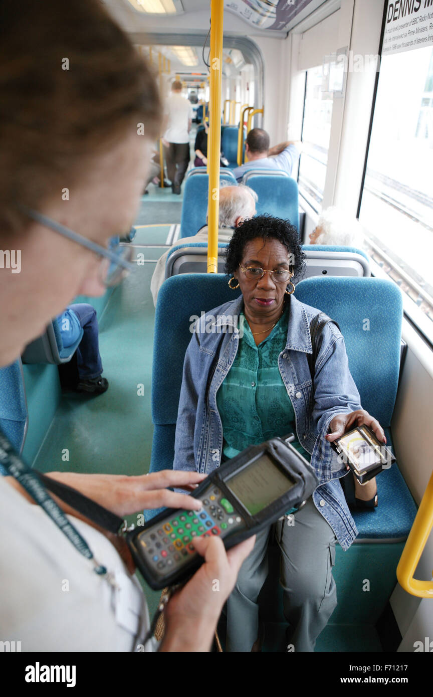 Woman showing her travel pass to the tram conductor Stock Photo - Alamy