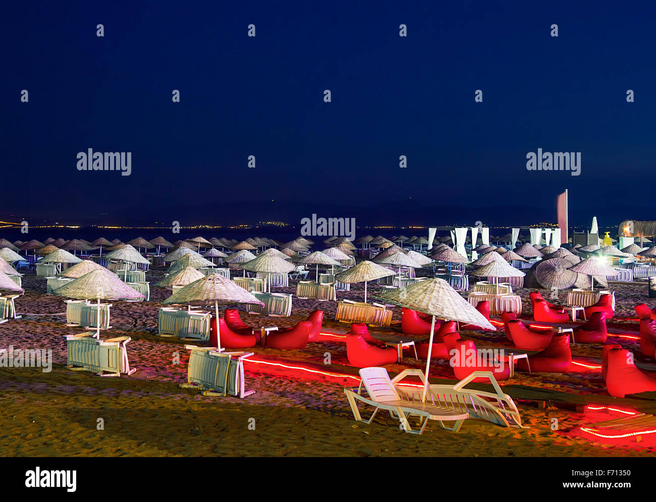 Beds and straw umbrellas on Sarimsakli Beach, Turkey At Night Stock ...