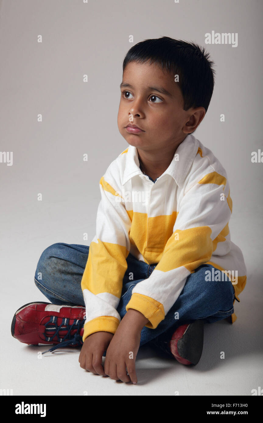 Young boy sitting cross legged on the floor Stock Photo - Alamy
