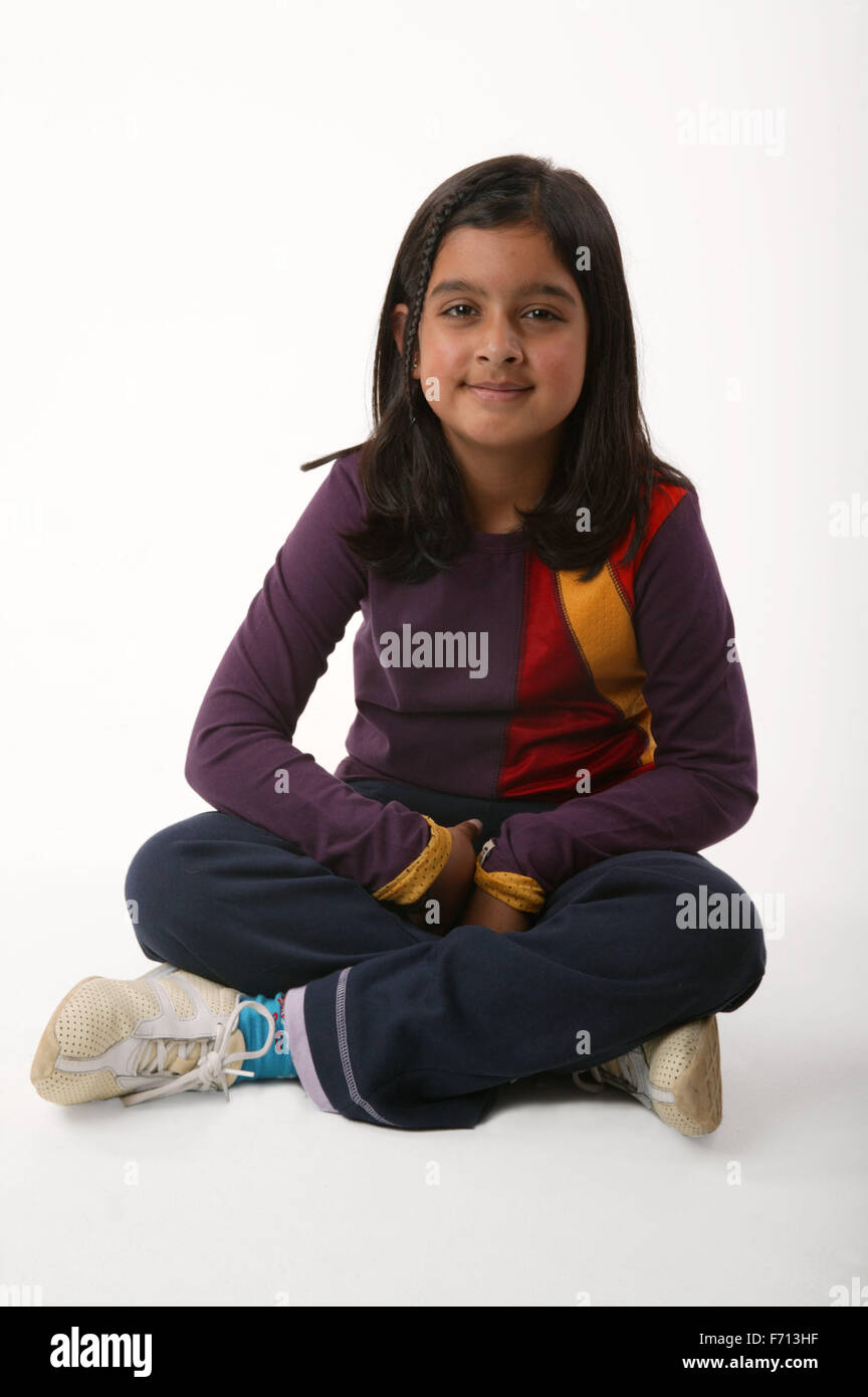 Young girl sitting cross legged on the floor Stock Photo - Alamy