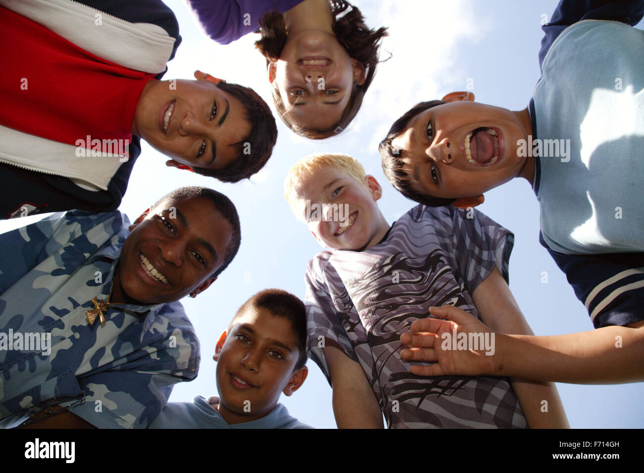 Group of teenagers faces looking down and smiling Stock Photo - Alamy