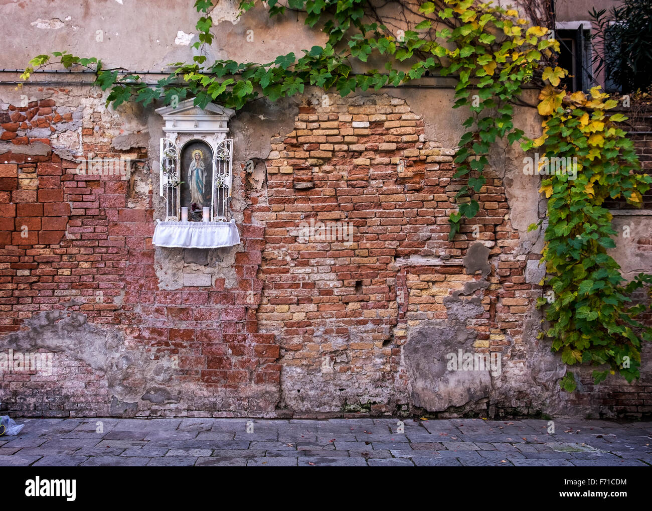 Roman Catholic religious shrine in water damaged brick wall, Venice ...