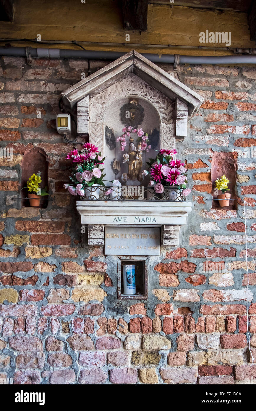 Roman Catholic religious shrine on water damaged brick wall, Venice ...