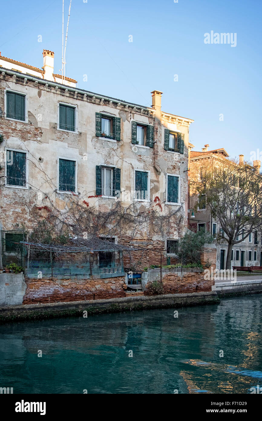 Venice, Italy. Water damaged old eroded house next to the Rio de l ...