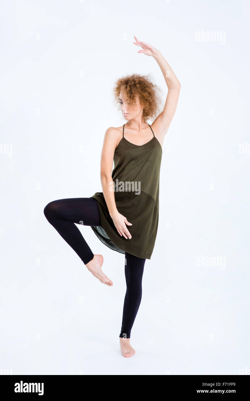 Full length portrait of a young woman with curly hair dancing isolated ...