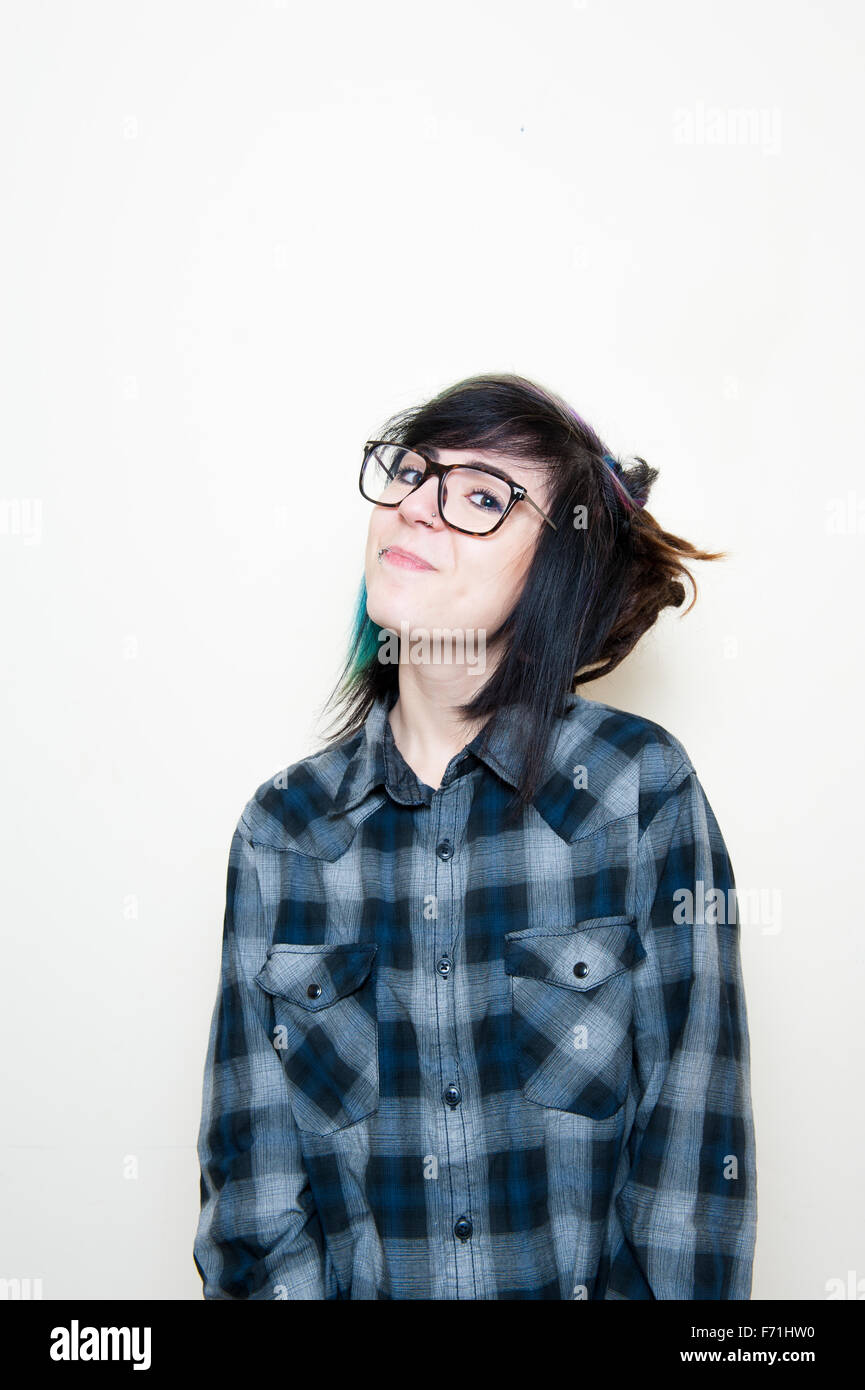 Pretty young alternative woman with big glasses smiling and looking at ...
