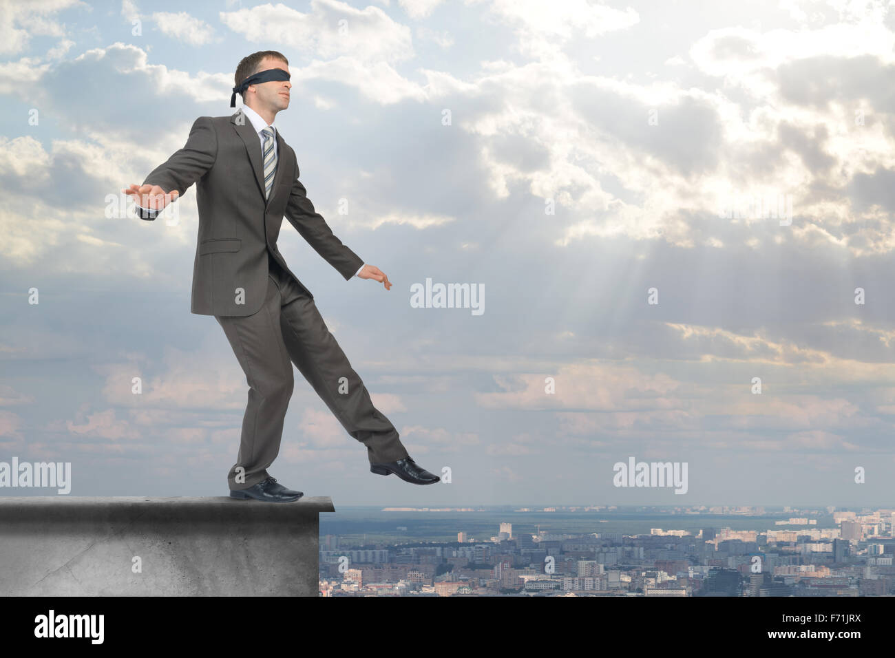 Businessman stepping from edge of building roof Stock Photo - Alamy