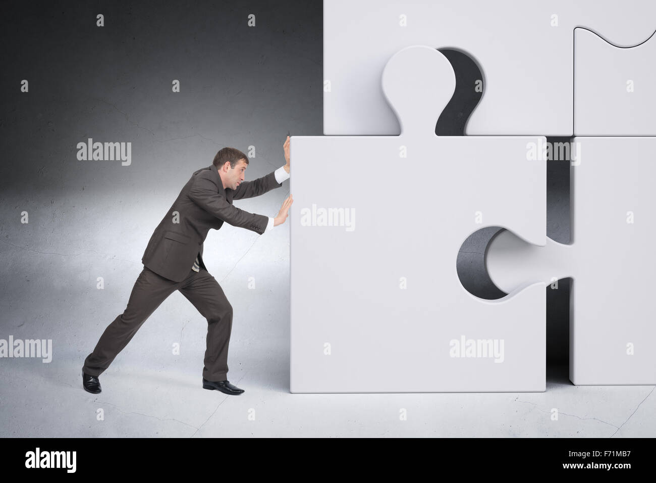 Businessman pushing puzzle piece Stock Photo - Alamy