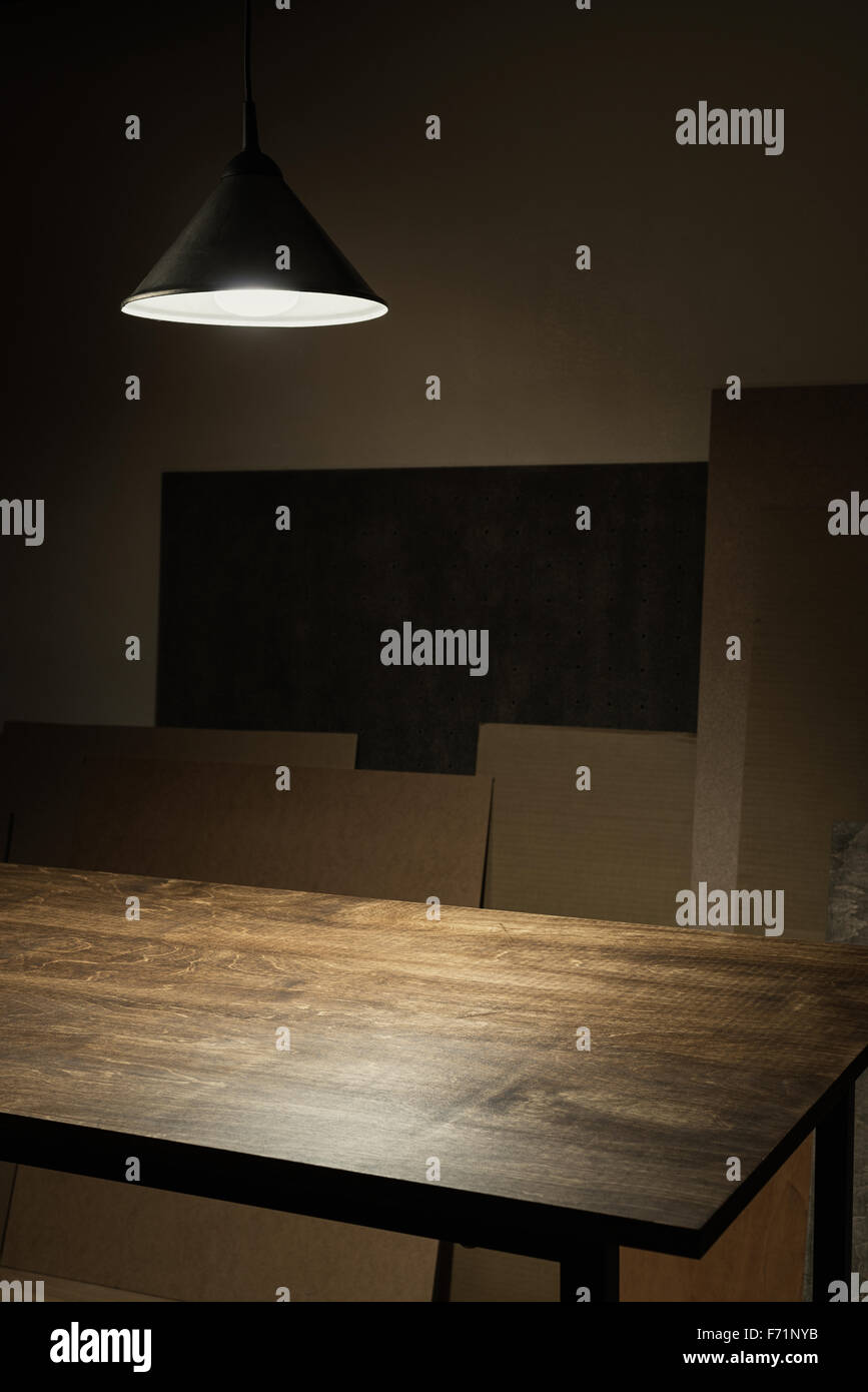 Lamp hanging over empty wooden table in workshop Stock Photo - Alamy