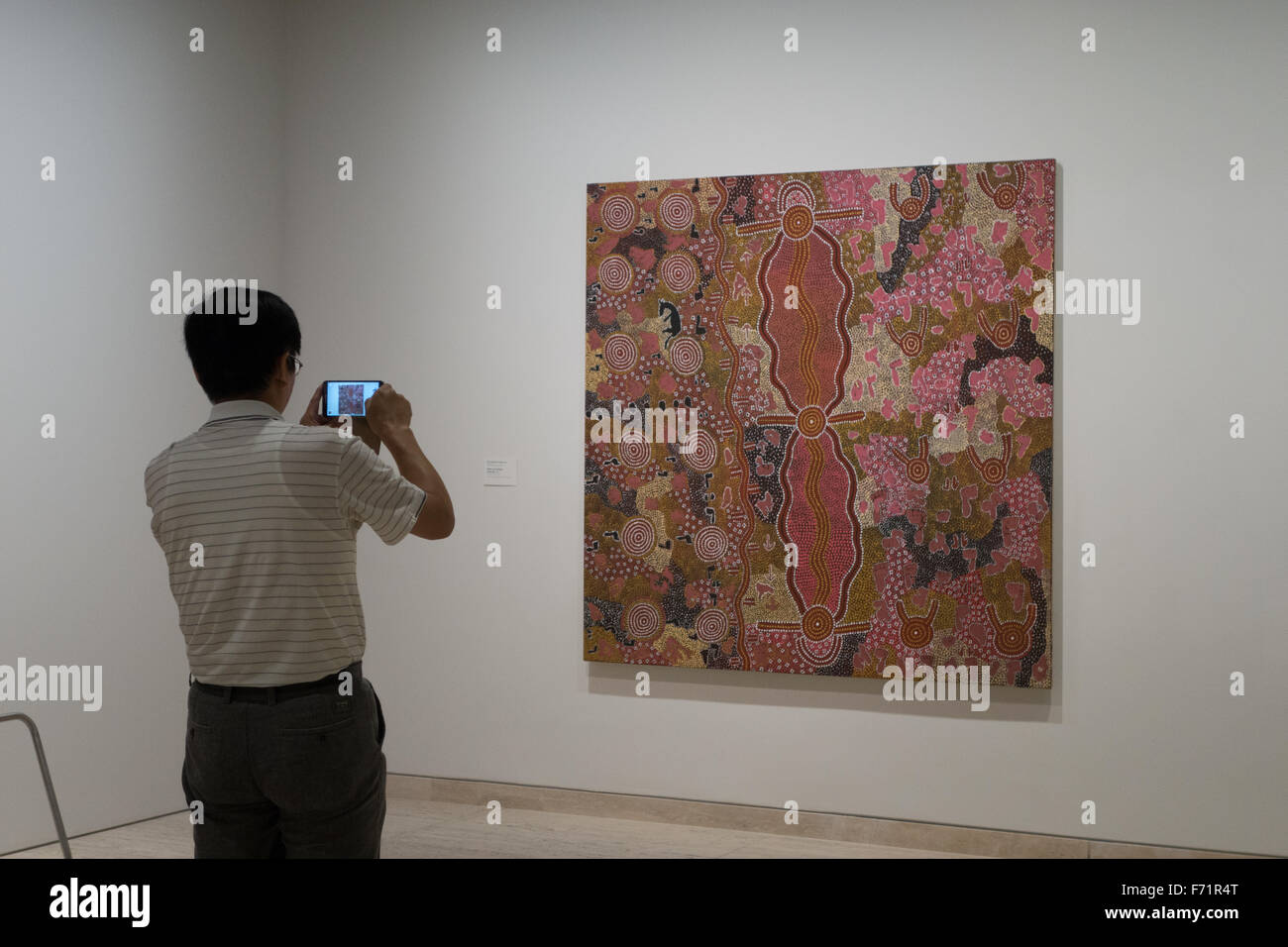man taking picture using cell phone inside art gallery Stock Photo - Alamy