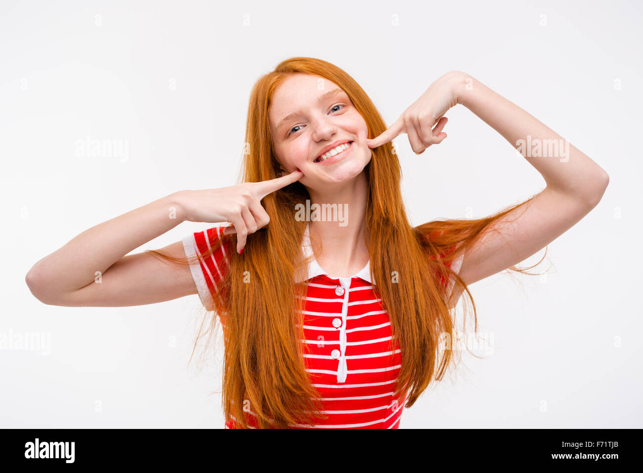 Positive Cheerful Redhead Young Woman Touching Her Cheeks With Fingers