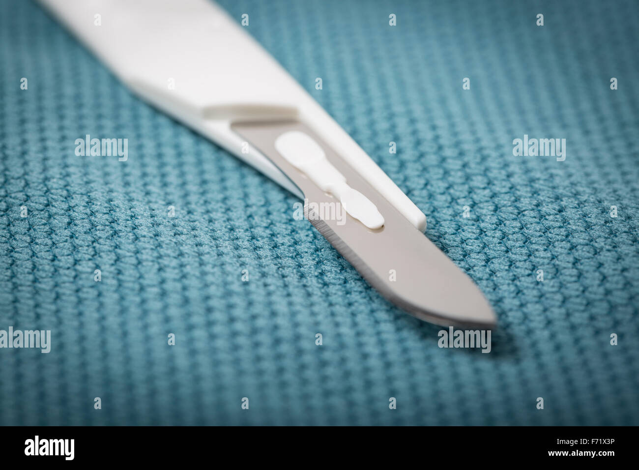 Detail of a scalpel on a tray covered with green cloth Stock Photo - Alamy