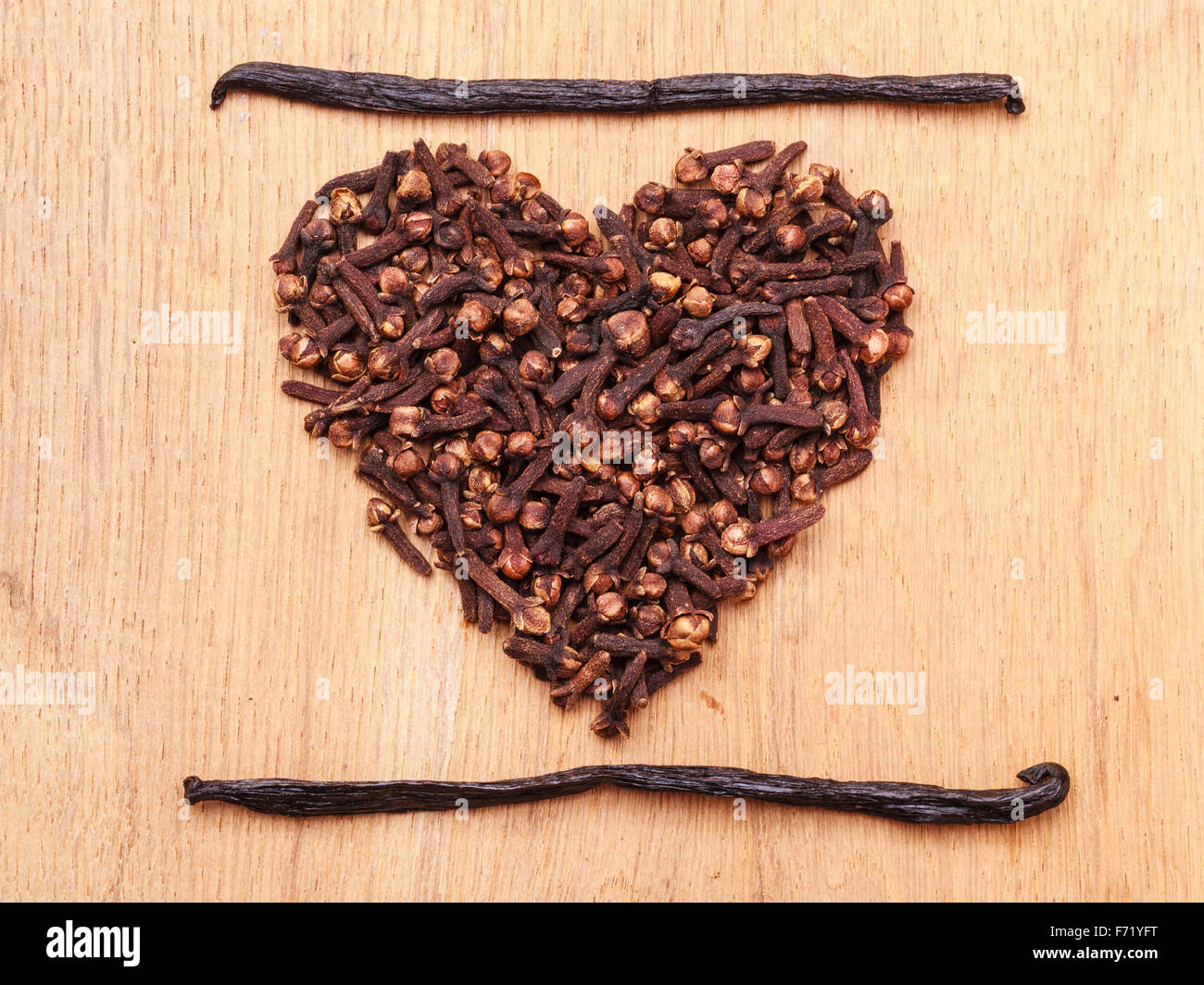 Heart form made from spice cloves on wooden background Stock Photo - Alamy